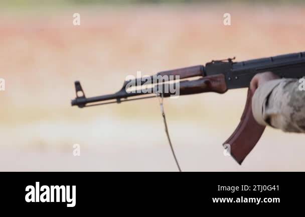 Armed military man unloading machine gun while lying with gun, soldier ...