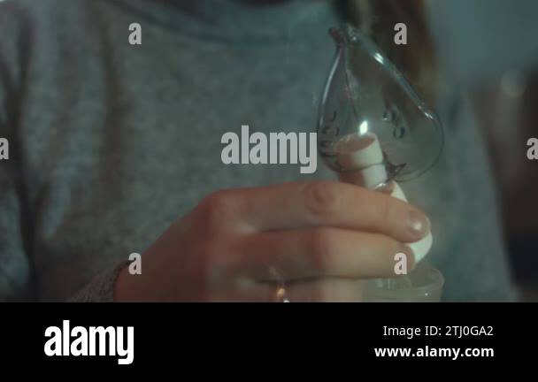 Beautiful little girl makes inhalation using a compressor inhaler while ...