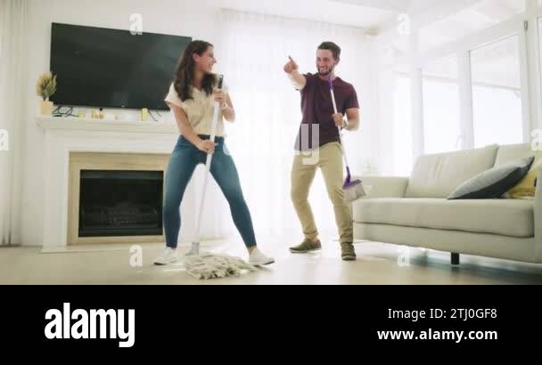 Couple Singing And Dancing While Cleaning Living Room People Doing