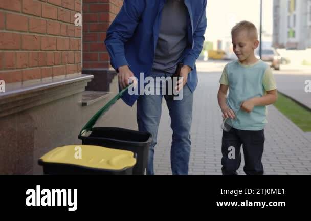 Dad teaches his son to properly sort garbage. Father and son sorting ...