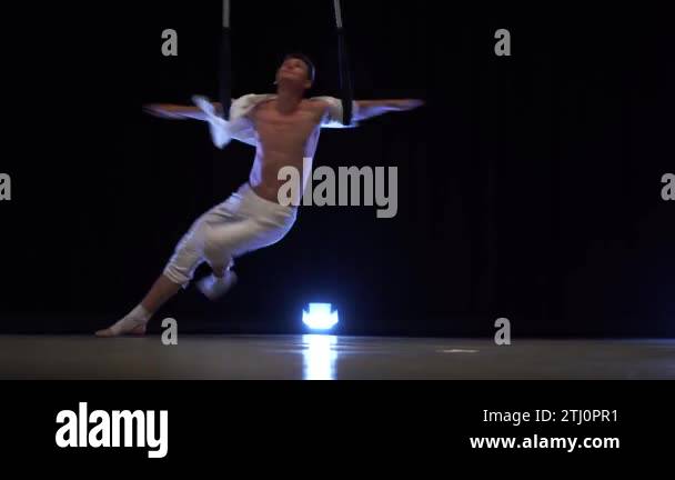 Muscular male aerial circus artist performances with dance trapeze ...