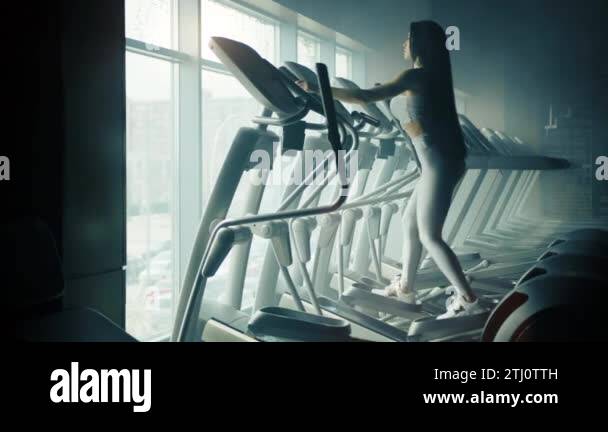 Young pretty well-built woman, long brown hair in sports wear ...