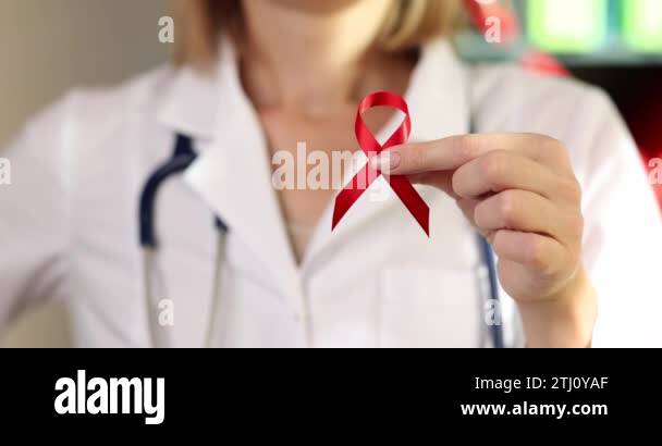 Red ribbon in hands of doctor as symbol of World AIDS Day. Disease ...