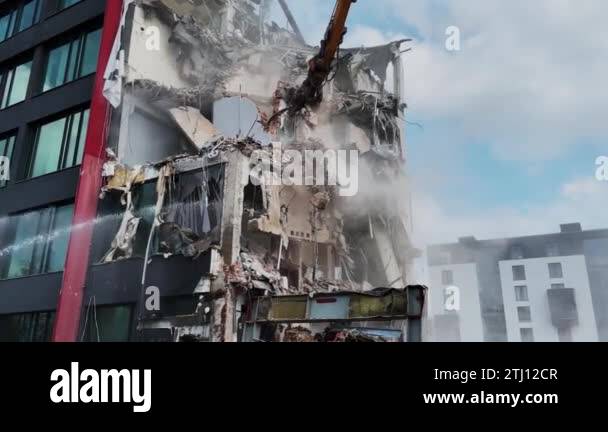 Rebuilding the city. Construction equipment demolishes an office block ...