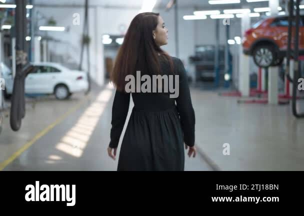 Back view young slim confident woman walking in slow motion in auto ...