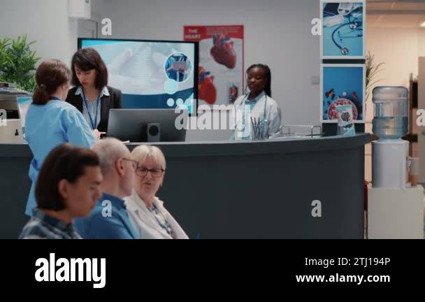 Female employee working at hospital reception counter to give ...