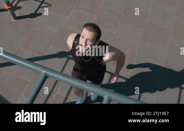 Athletic lebanese man in sportswear doing pull ups exercises on horizontal bar. Young guy ...