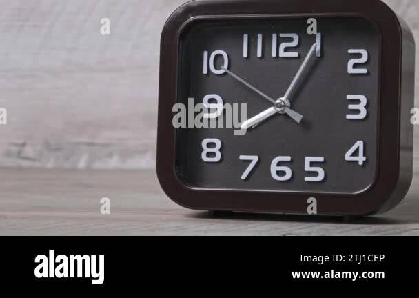 The pointer clock on wooden table shows time 8 oclock. Arrow brown ...