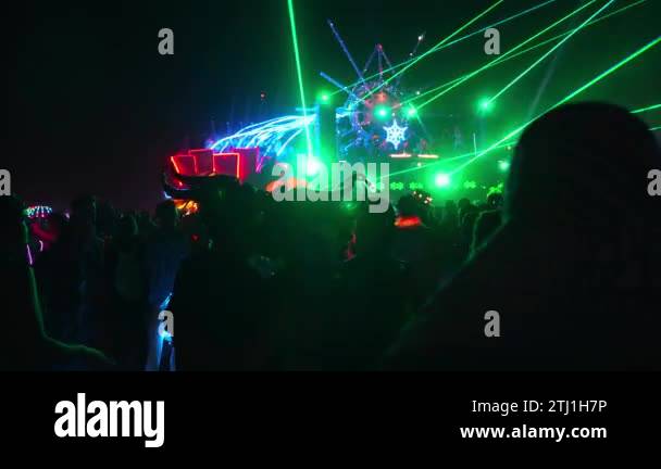 Laser light show with people dancing at night in the middle of a desert ...