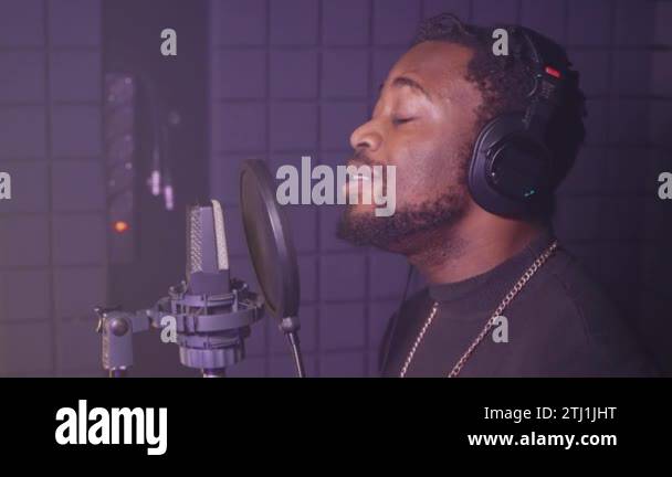 romantic singer man is recording back vocal parts in professional ...