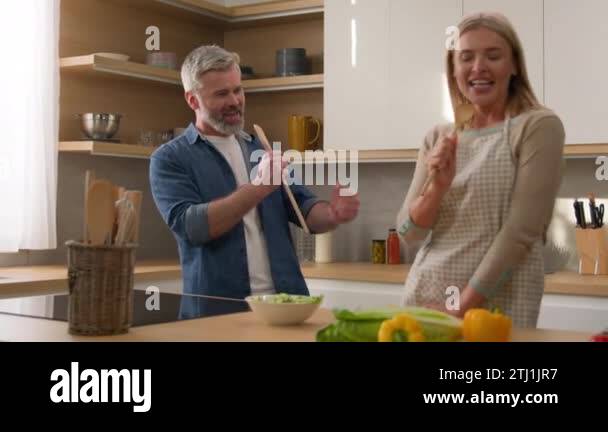 Middle-aged couple happy family cheerful wife and husband singing song ...