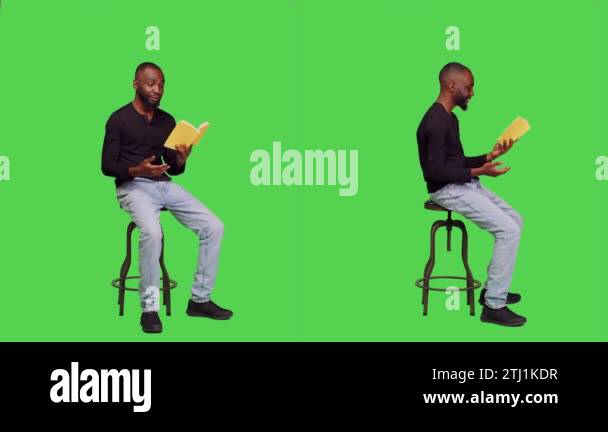 Male model reading novel story on book in studio, sitting on chair over ...