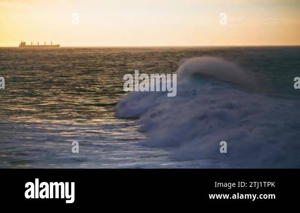 Winter waves rolling seashore in slow motion. Travel ship silhouette at horizon. Foamy ocean ...