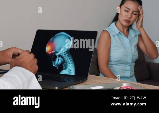 Doctor showing x-ray of pain in the front of the brain on a laptop with ...