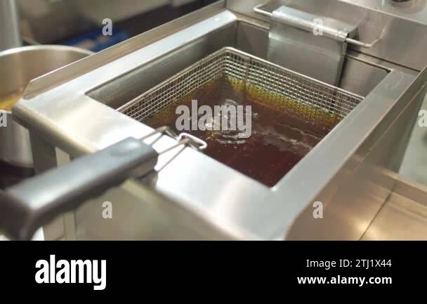 Cooking oil boiling and bubbling in fryer for deep frying dishes in a ...