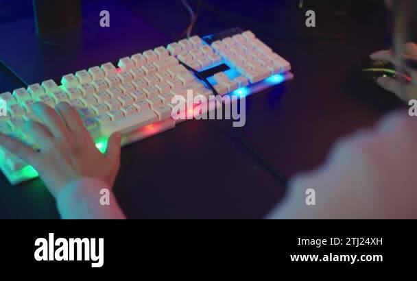 Close up gamer hands actively pushing buttons with colorful neon LED ...