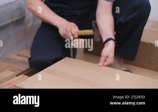 skilled handyman in coveralls brings to life a piece of furniture using ...