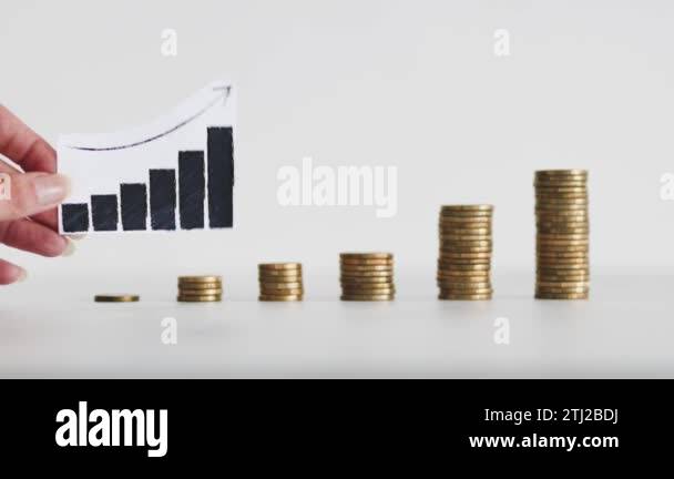 rising inflation graph in front of growing stacks of coins representing ...