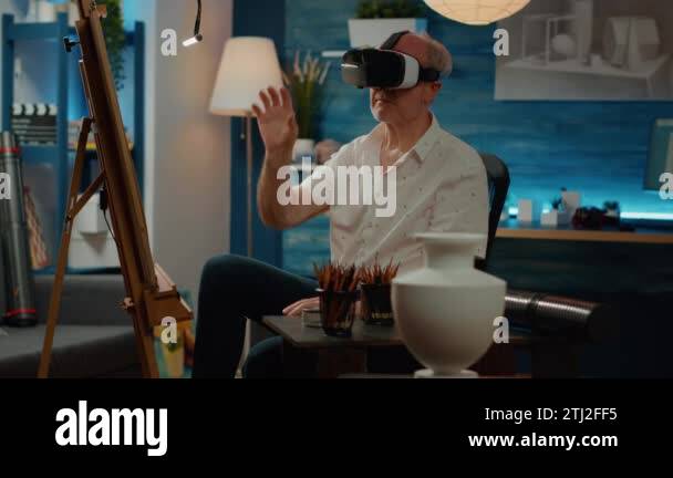 Retired artist using futuristic vr glasses and tools to draw on canvas ...