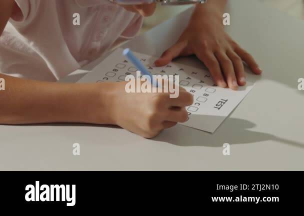 Close up girls hand filling out answers. Female pupil doing test on the ...