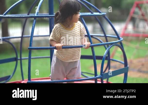 Cute asian girl smile play on school or kindergarten yard or playground ...