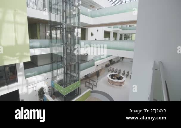 Elevator by connecting bridges and glass ceiling in hallway of shopping ...