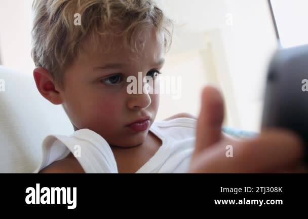 Kid face staring at screen close-up. Hypnotized child watching media ...