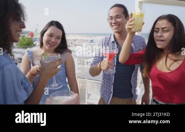 Slow motion Friends at summer party cheers dance and having fun drink ...