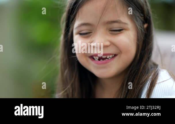Portrait of a happy little girl closeup face with missing teeth. A ...