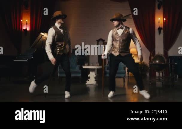 Two stylish professional male dancers in dandy hat walking to camera in ...