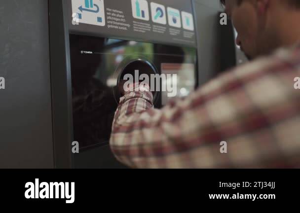 A man returns plastic bottles in a German supermarket. Reverse vending ...