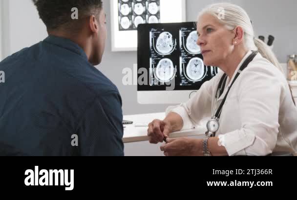 Close up of female senior doctor explaining ct scans to patient after ...