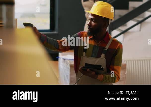 Male employee scanning barcodes with scanner, inspecting stock ...