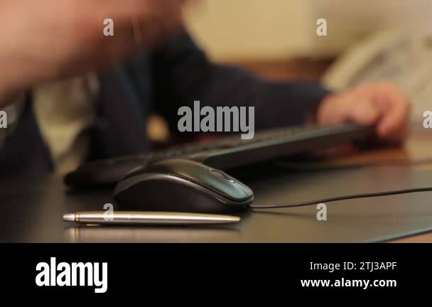 Male hand, close-up. A man works with a computer mouse and types on a ...