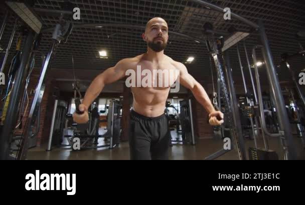 Shirtless muscular man covered in sweat working out his arm and back ...