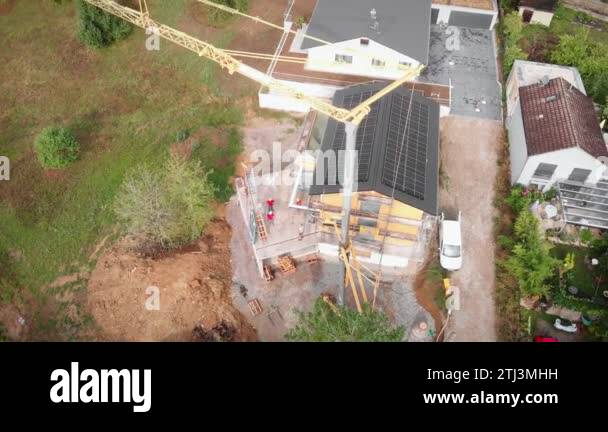 Construction crane carrying windows at construction site. House cottage ...