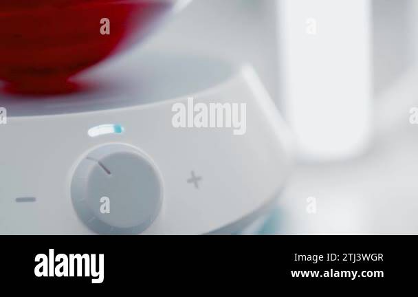 Bright laboratory. Round glass flask. Red liquid boils in the flask ...