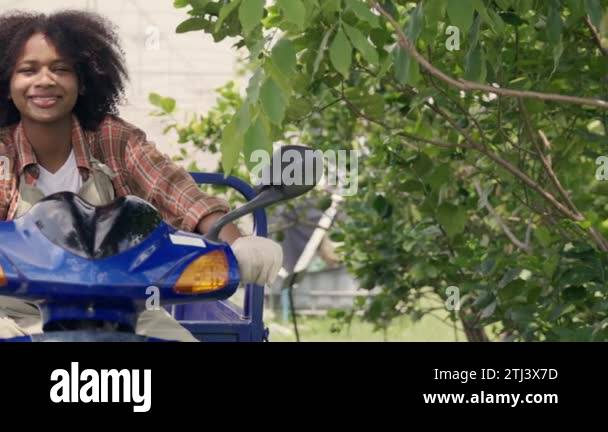 Happy children girl farmer sitting on tricycle in hydroponics farm ...