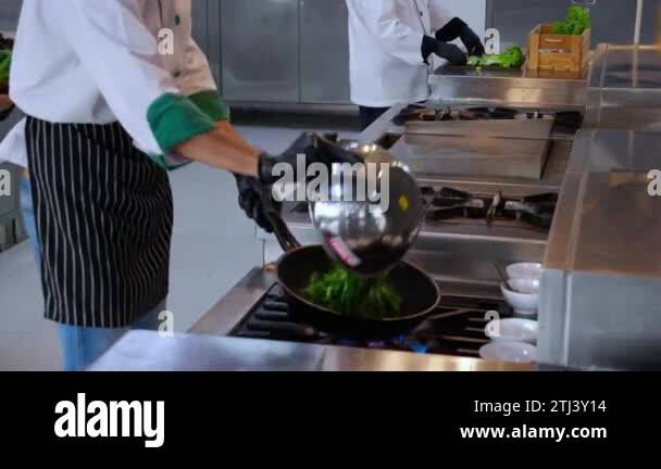Closeup hands of chef man stir frying morning glory fire flame with ...