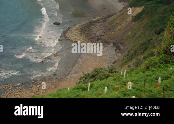 Waves of raging sea roll on pebble beach forming white foam on windy ...