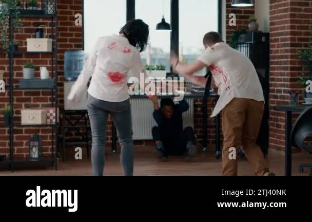 Infected dangerous zombies chasing man in office workspace. Afraid businessman hiding under ...