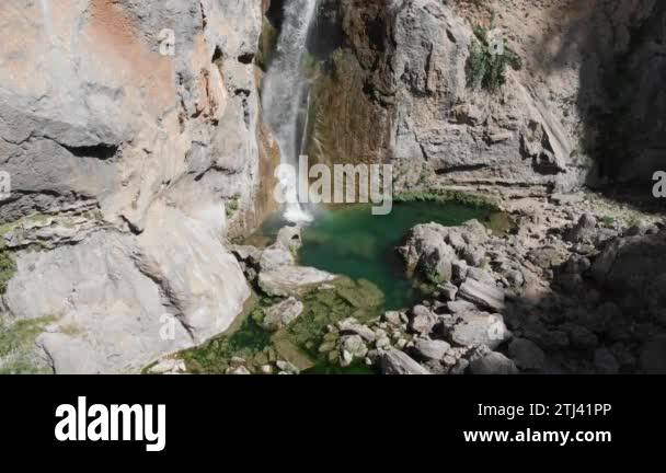 Still steady shot slowly zooming out as freshwater drops from a cliff ...