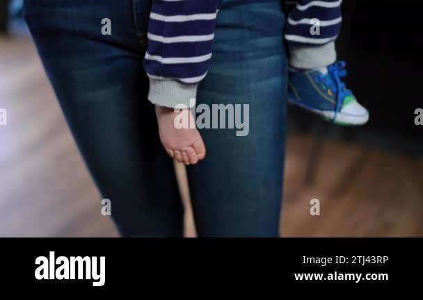 Barefoot leg of infant girl and foot in sneakers close-up ...