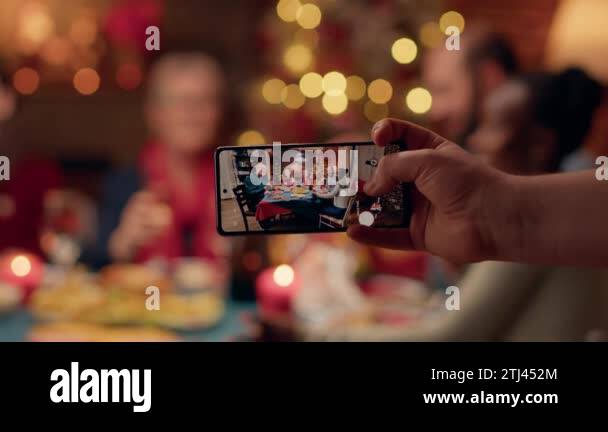 Person taking photo of happy people celebrating winter holiday with ...