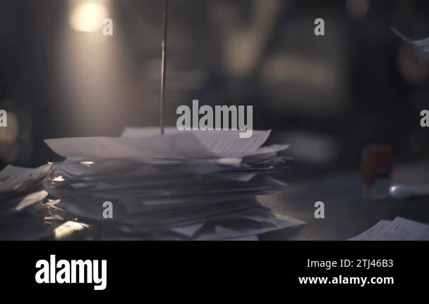 Paper sheets on a steel spoke. A man's hand attaches completed tasks of ...