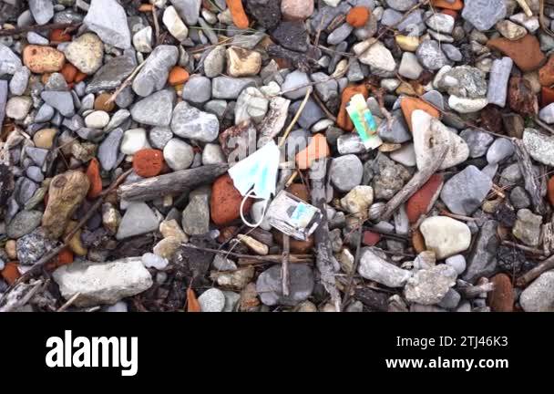 Plastic waste covers and garbage on pebble at seashore after storm ...