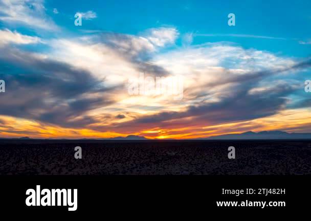A golden sunrise over the Mojave Desert basin with the glow of the sun ...