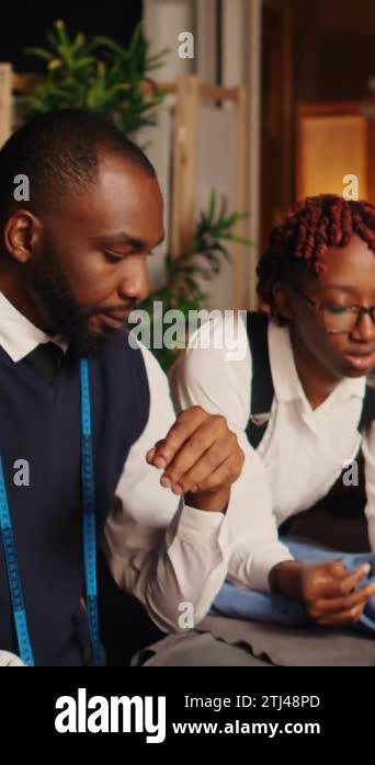 Vertical video African american tailors picking fabric to create luxury fashion collection with ...