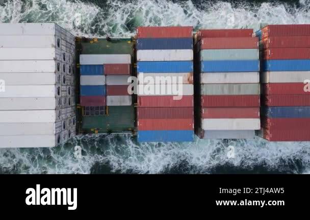 Aerial top view of a container ship sails on the sea, its massive hull ...