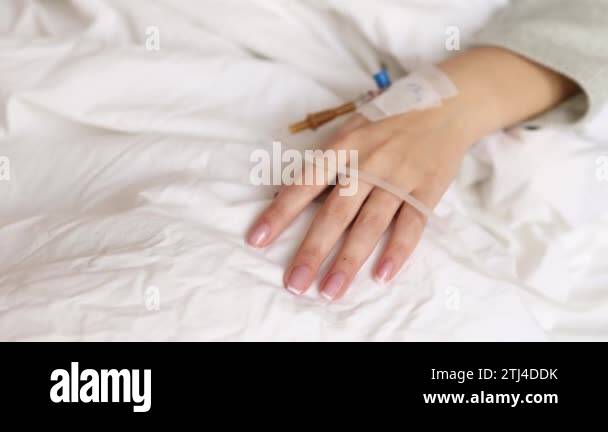 Close-up female hand, she is having a catheter inserted inside of a ...